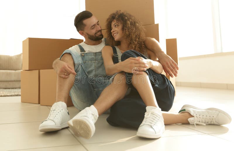 Married Couple Sitting Near Cardboard Boxes In A New Apartment Stock