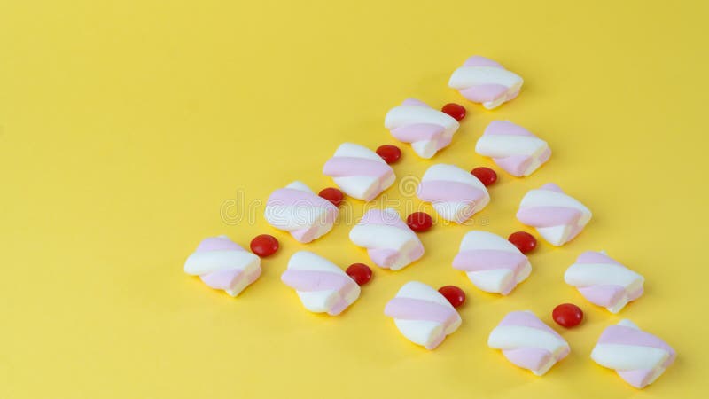 Marshmallows and Red Candy Dragees Lined Up with a Christmas Tree Stock ...