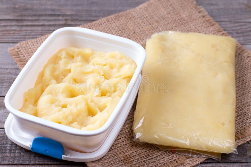 Mashed Potatoes in a Container and a Bag on a Table Stock Photo - Image ...