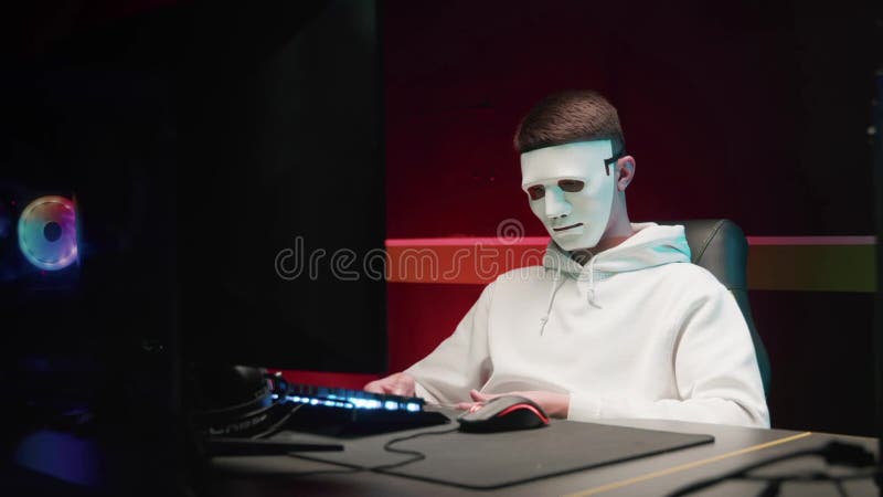 A Masked Hacker Breaks Into A Database On A Computer Hacking In A Dark