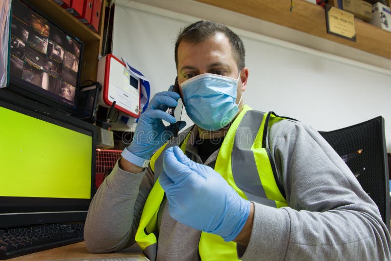 A Masked Man at a Table Works on a Computer in Office Stock Image ...