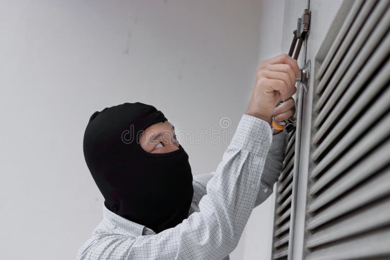 Masked Robber Using a Lock Picking Tool To Breaking and Entering into a ...