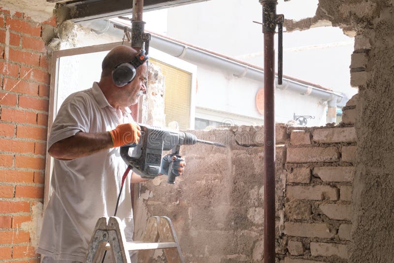 Mason Breaking a House Wall with a Demolition Hammer. Stock Image ...