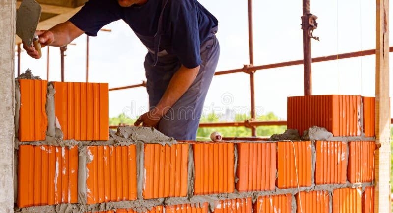 Worker is Building Wall with Red Blocks and Mortar Stock Photo - Image ...