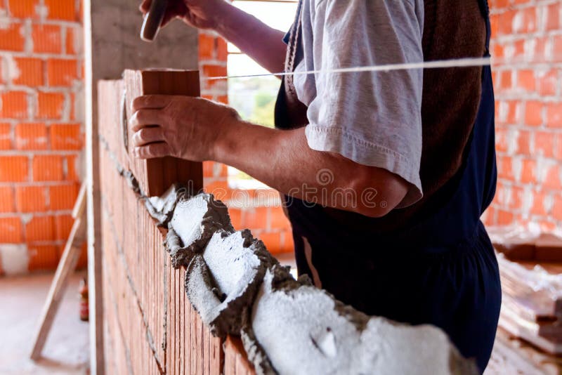 Worker is Building Wall with Red Blocks and Mortar Stock Photo - Image ...