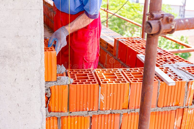 Worker is Building Wall with Red Blocks and Mortar Stock Photo - Image ...