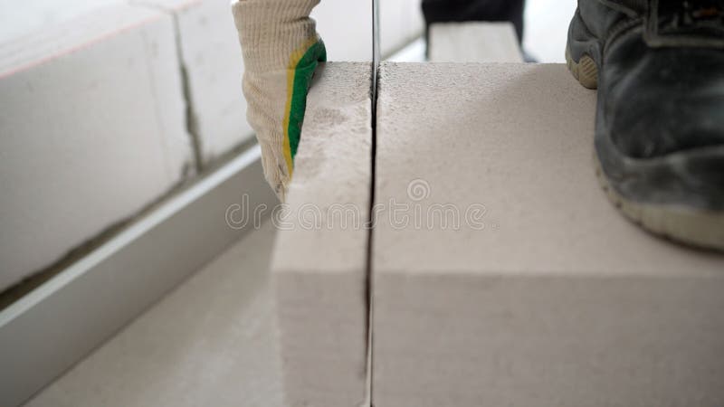 A Worker Saws White Building Blocks. a Builder Cuts White Brick Blocks ...