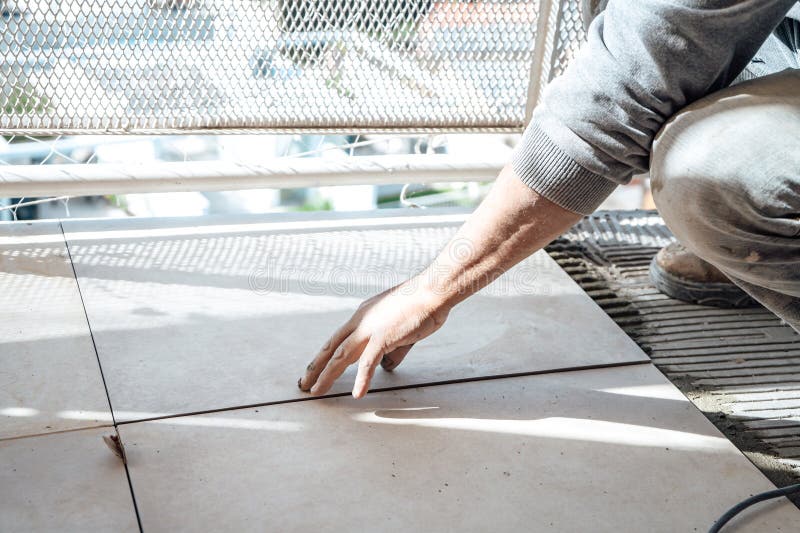 Mason Laying a Tile in the Space Prepared in the Floor. I Work in a ...