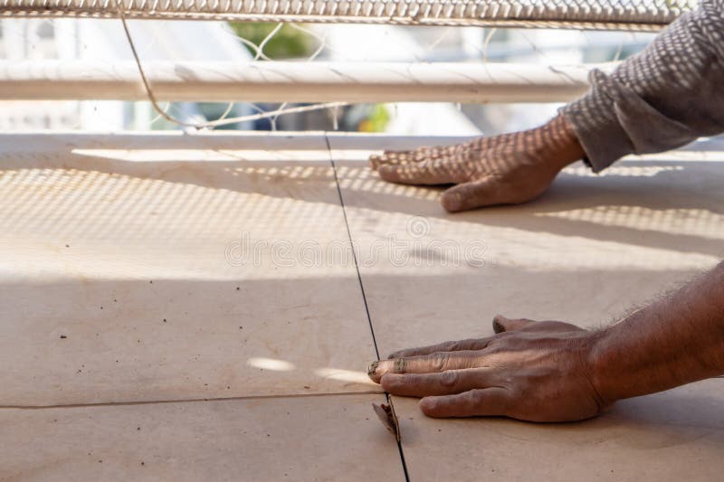 Mason Laying a Tile in the Space Prepared in the Floor. I Work in a ...