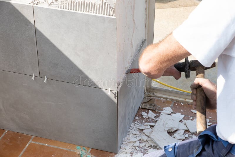 The Mason Prepares the Wall with a Chisel before Laying a Ceramic Tile ...