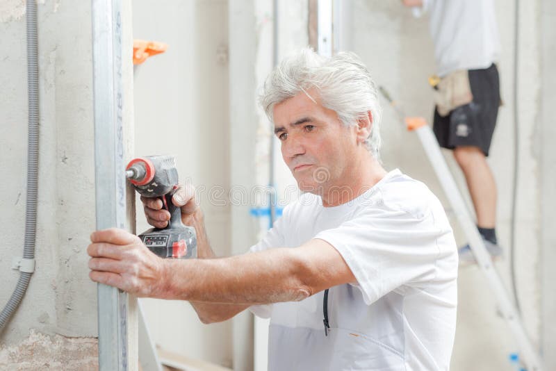 Mason using a drill stock image. Image of professional - 232647827