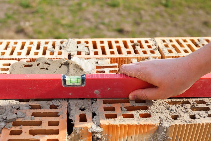 Mason Worker Measuring with Professional Level the Bricks Under ...
