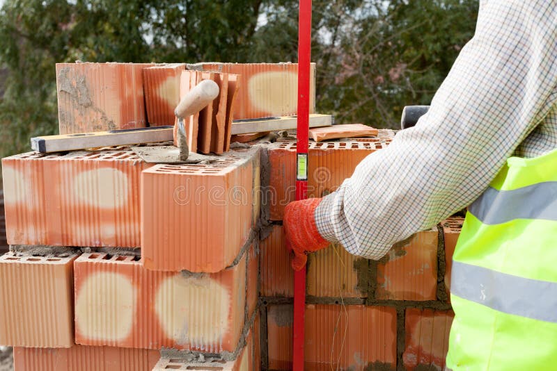 Mason Worker Measuring with Professional Level the Bricks Under ...