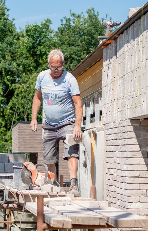 Masonry Worker the Bricklayer Makes the Facade of the House from Gray ...