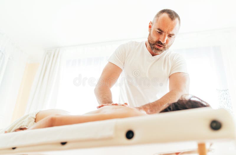 Masseur Man Doing Massage Manipulations on the Client Back and ...