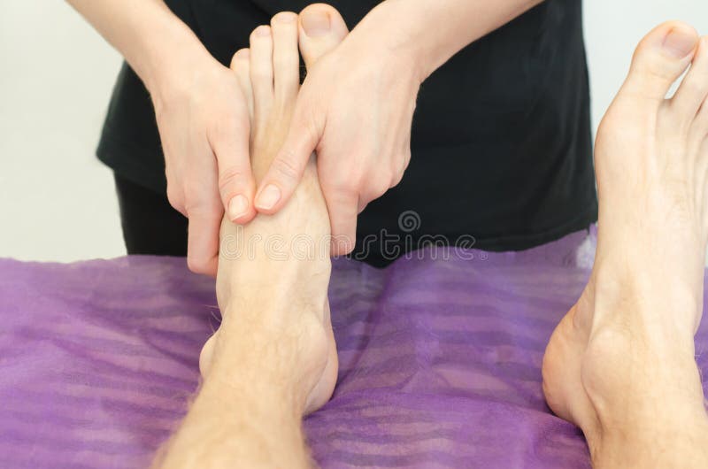 The Masseuse Makes A Relaxing Foot Massage To A Man Foot Massage Stock