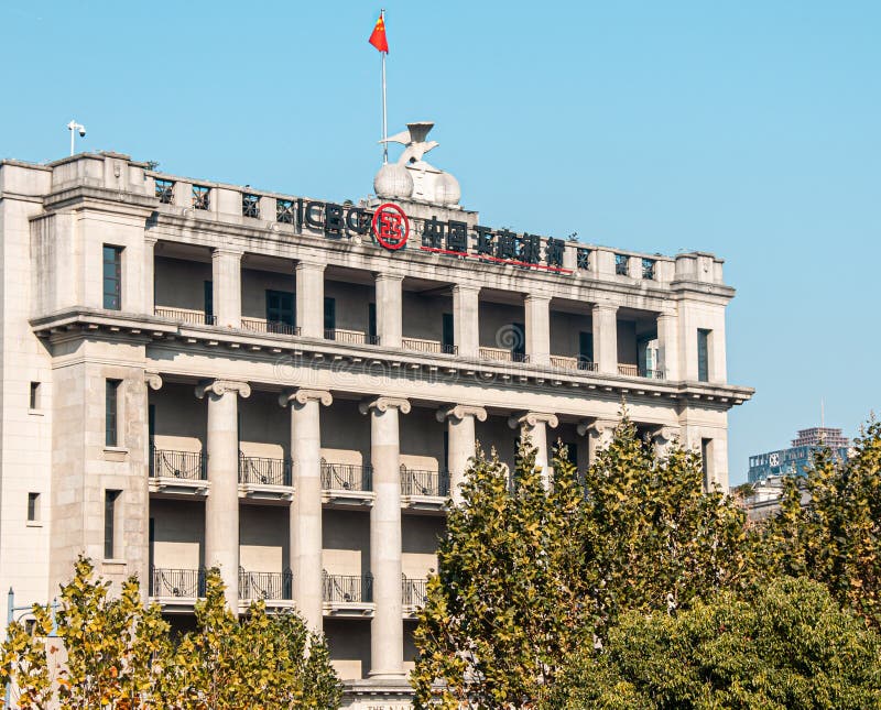 A Very Large Grey Building with Several Flags Flying High on Top ...