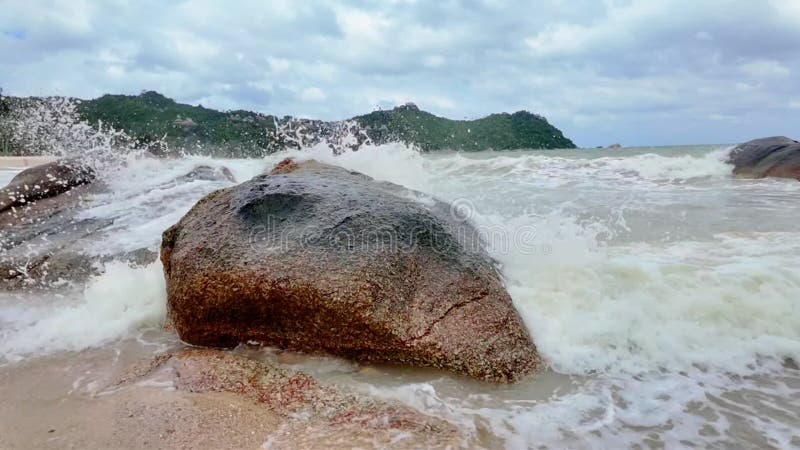 A Massive Rock Rests on the Sandy Beach beside the Flowing Ocean Waters ...