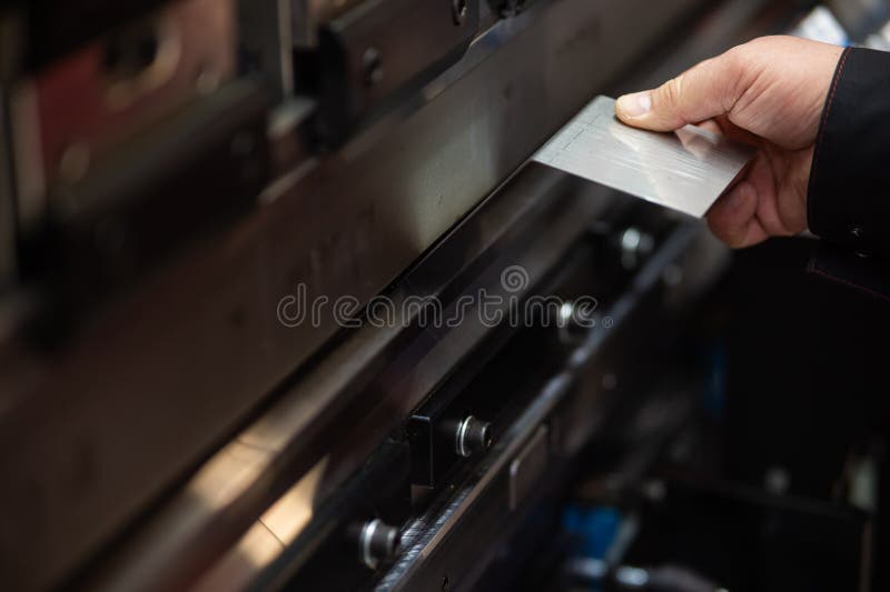 A Master Bends Metal Sheets on a Machine. Hydraulic Press. Stock Image ...