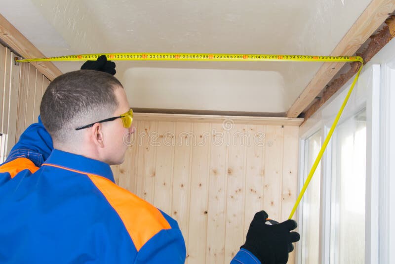 A Master in a Blue Uniform and Black Gloves Measures the Distance ...