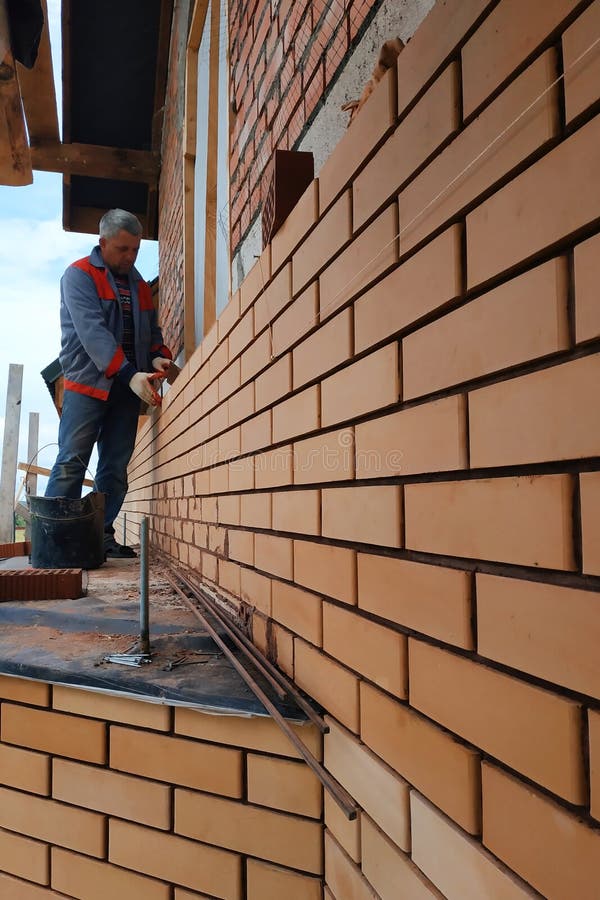 The Master Builds a Wall of a House from a Front Brick Stock Photo ...