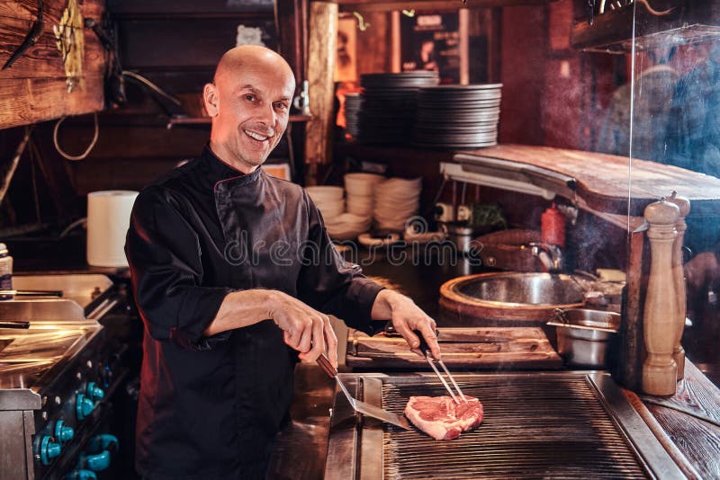 Master Chef Wearing Uniform Cooking Delicious Beef Steak on a Kitchen ...