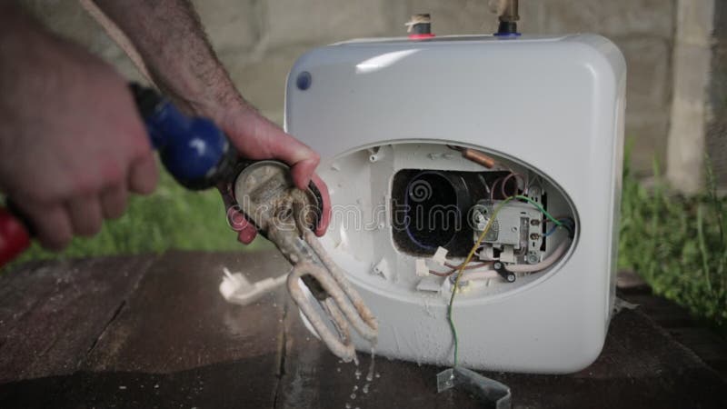 The Master Cleans the Water Heating Element of the Boiler Using a ...
