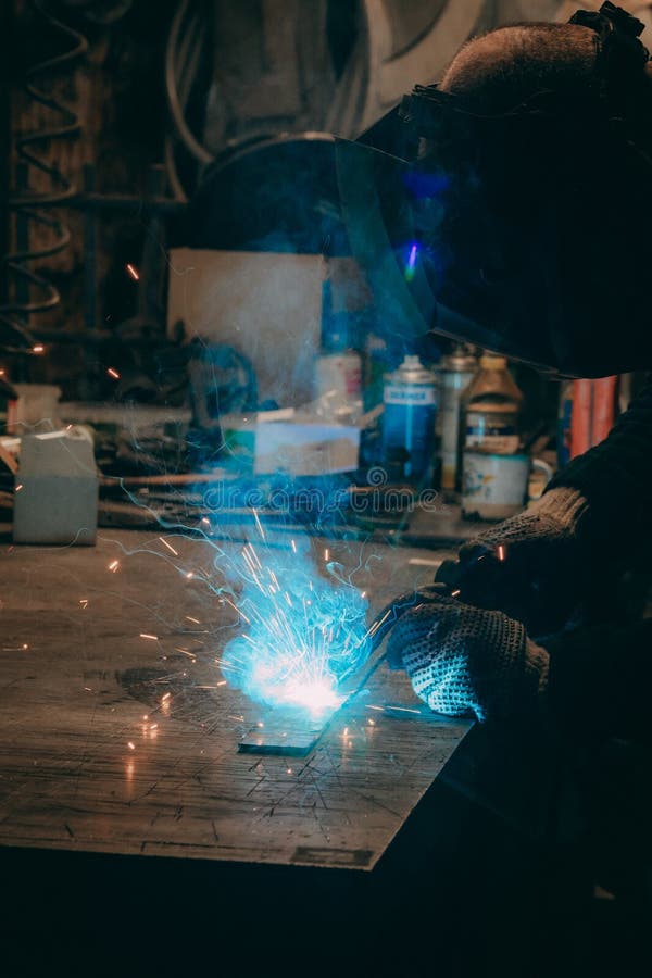 Master is Doing Welding at His Workplace in the Workshop, while Sparks ...