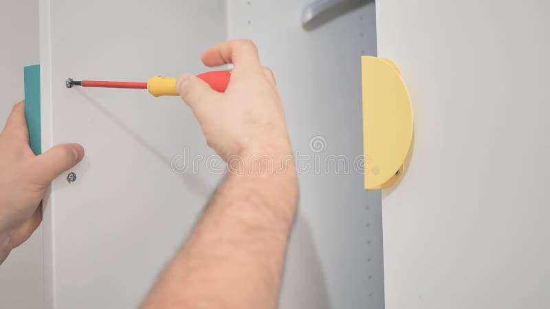 The Master Drills a Hole in the Wall with a Drill, Inserts a Screw ...