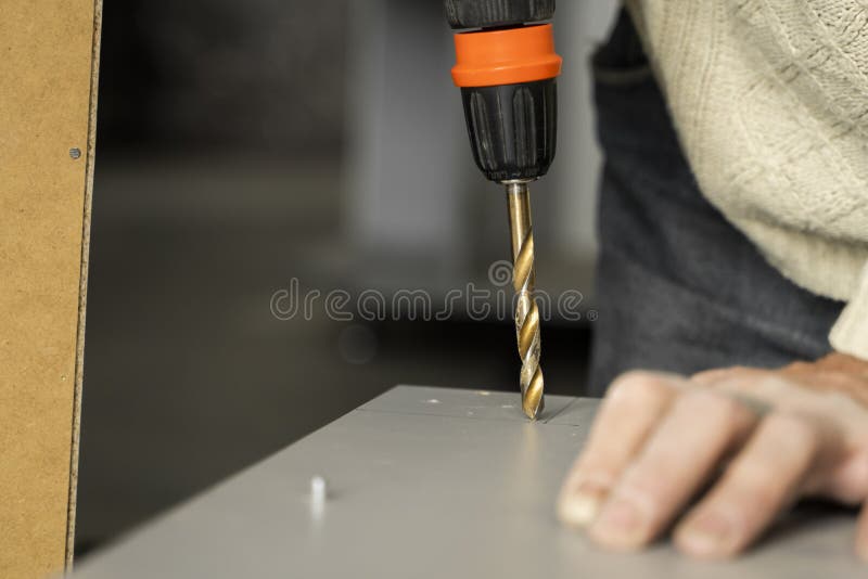 The Master Drills a Wooden Plate from Chipboard with a Drill. Stock ...