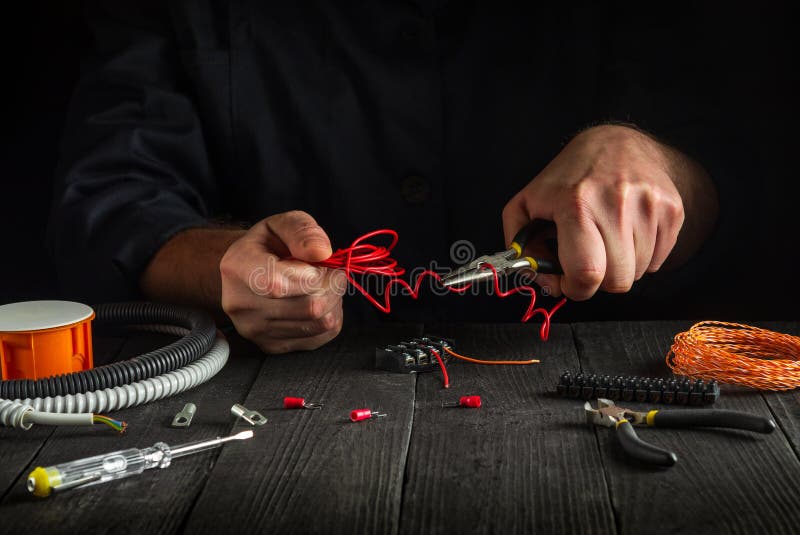 Master Electrician Repairs Electrical Equipment in Workshop. Connecting ...