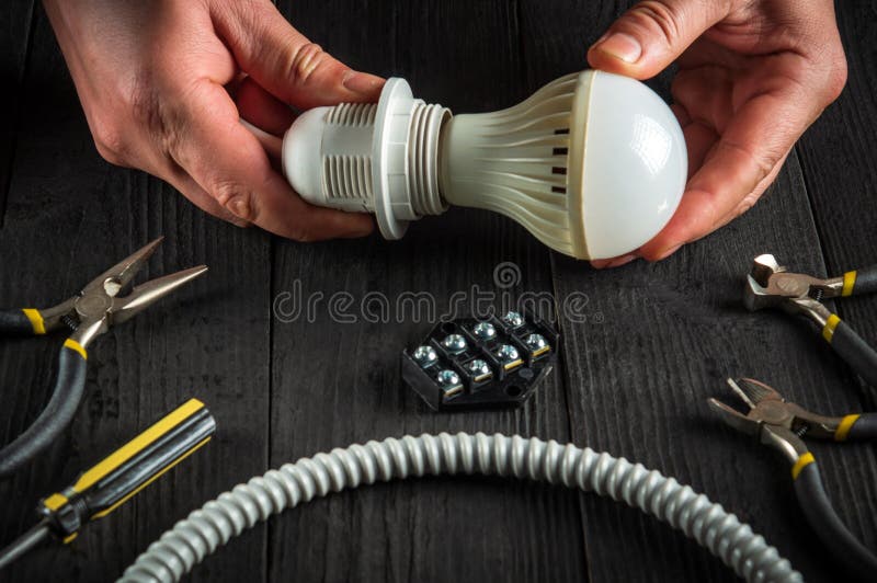 Master Electrician Turns on the Light Bulb. Close Up of Worker Hands on ...