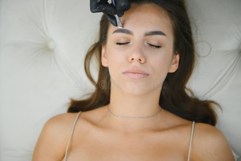 The Master Holds a White Pencil and Draws the Shape of the Eyebrows for ...