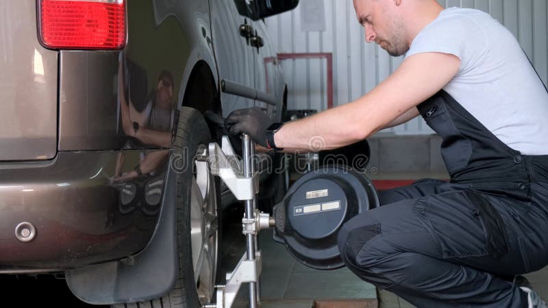 The Master Makes the Camber of the Wheels of the Car. Balancing the ...