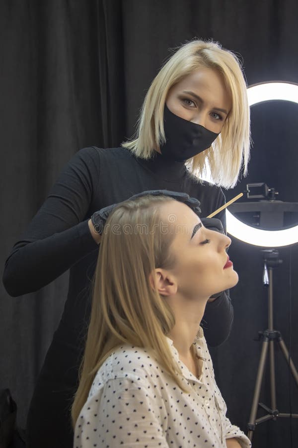 A Master Makeup Artist Touches Up the Client`s Eyebrows with a Thin ...