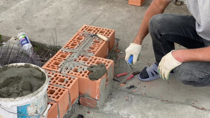 A Master Mason is Laying a Red Brick Wall. the Master at the ...