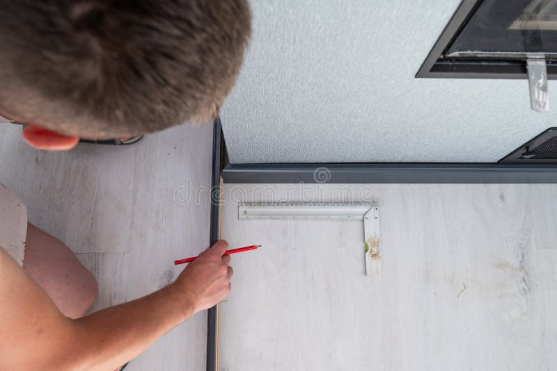 The Master Measures the Length of the Plinth for Cutting, Installing ...