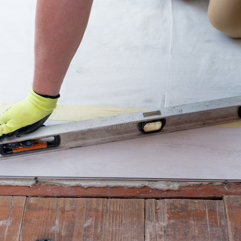 The Master Measures the Level of the Floor Surface. Stock Photo - Image ...