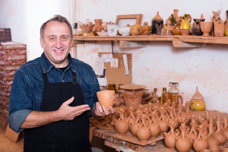 The Master of Pottery Makes Dishes from Brown Clay. Folk Art Stock ...