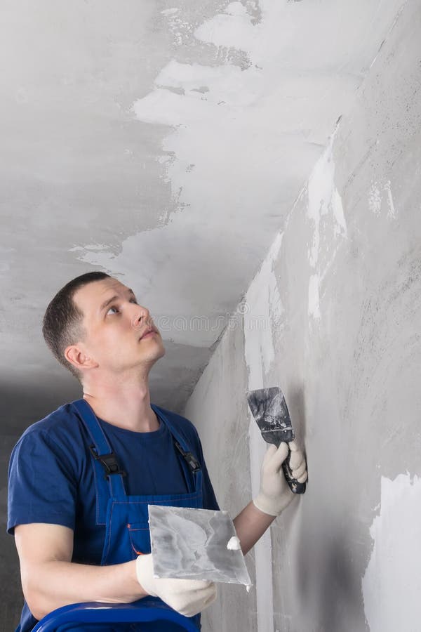The Master Processes the Seams of the Corners of the Ceiling with Putty ...
