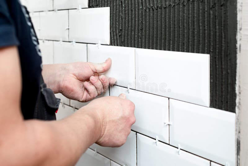 The Master& X27;s Hands Press a White Ceramic Tile Against the Wall the ...