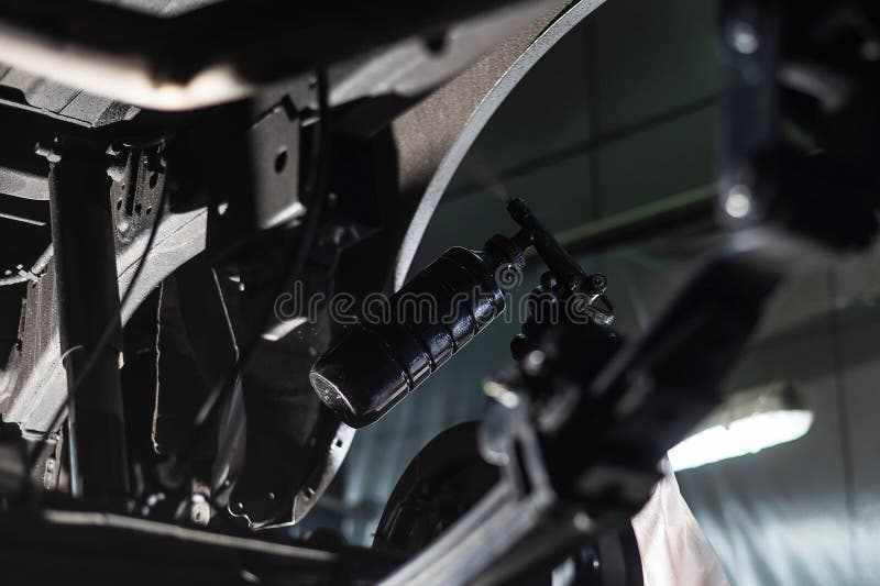 The Master Sprays an Anti-corrosion Compound on the Bottom of the Car ...