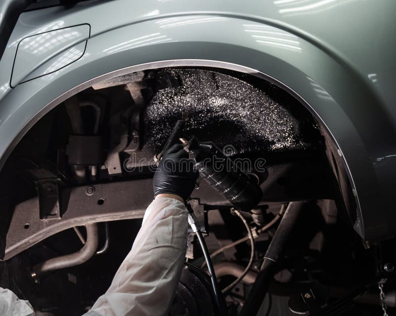 The Master Sprays an Anti-corrosion Compound on the Bottom of the Car ...
