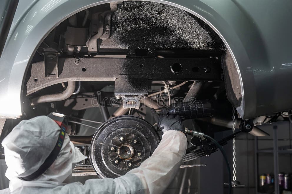 The Master Sprays an Anti-corrosion Compound on the Bottom of the Car ...