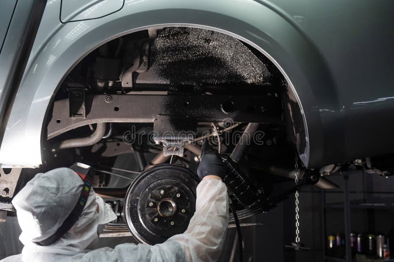 The Master Sprays an Anti-corrosion Compound on the Bottom of the Car ...
