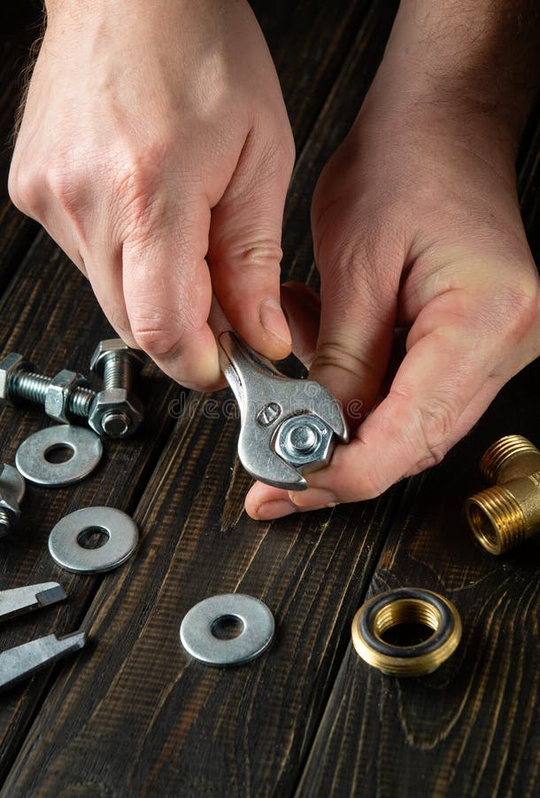 The Master Tightens the Nut with a Wrench on the Bolt. Work Environment ...