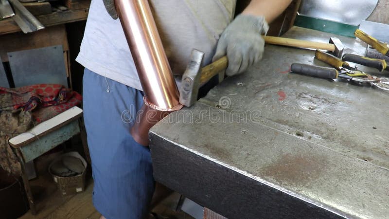 The Master Tinsmith Knocks Down the Connecting Lock on the Copper Pipe ...