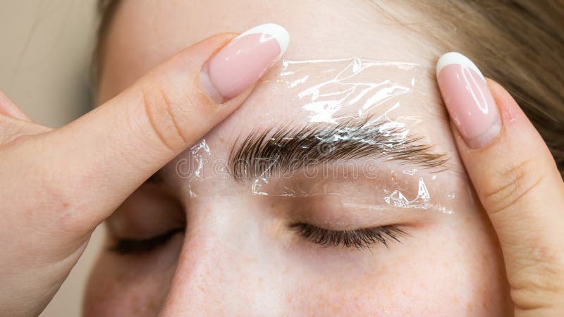 The Master Uses a Plastic Film during Lamination of the Eyebrows. Stock ...