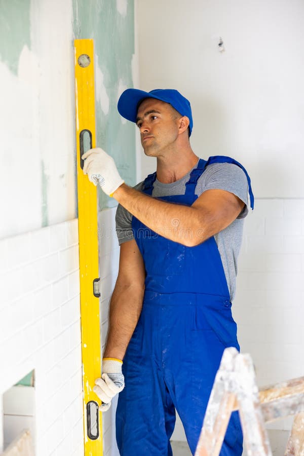 Master Wearing Work Clothes Checking Vertical of Installing Tiles Using ...