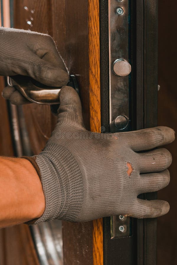 The Master Worker Installs a Door Lock in the Front Door, Metal Doors ...